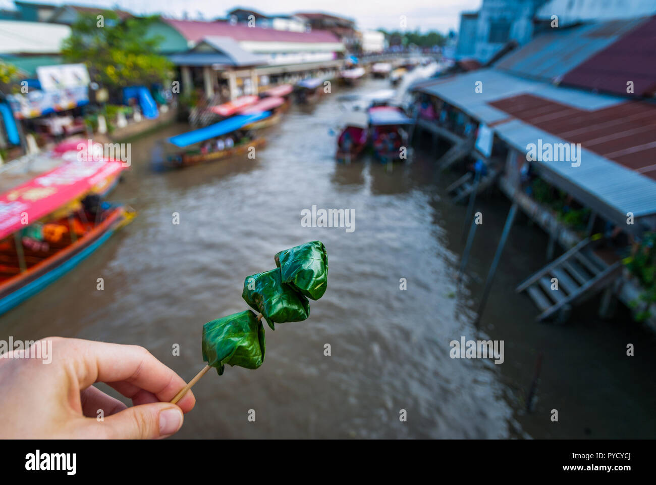 Wrapped Ming kham on a stick thai food, over the water canal of Amphawa ...