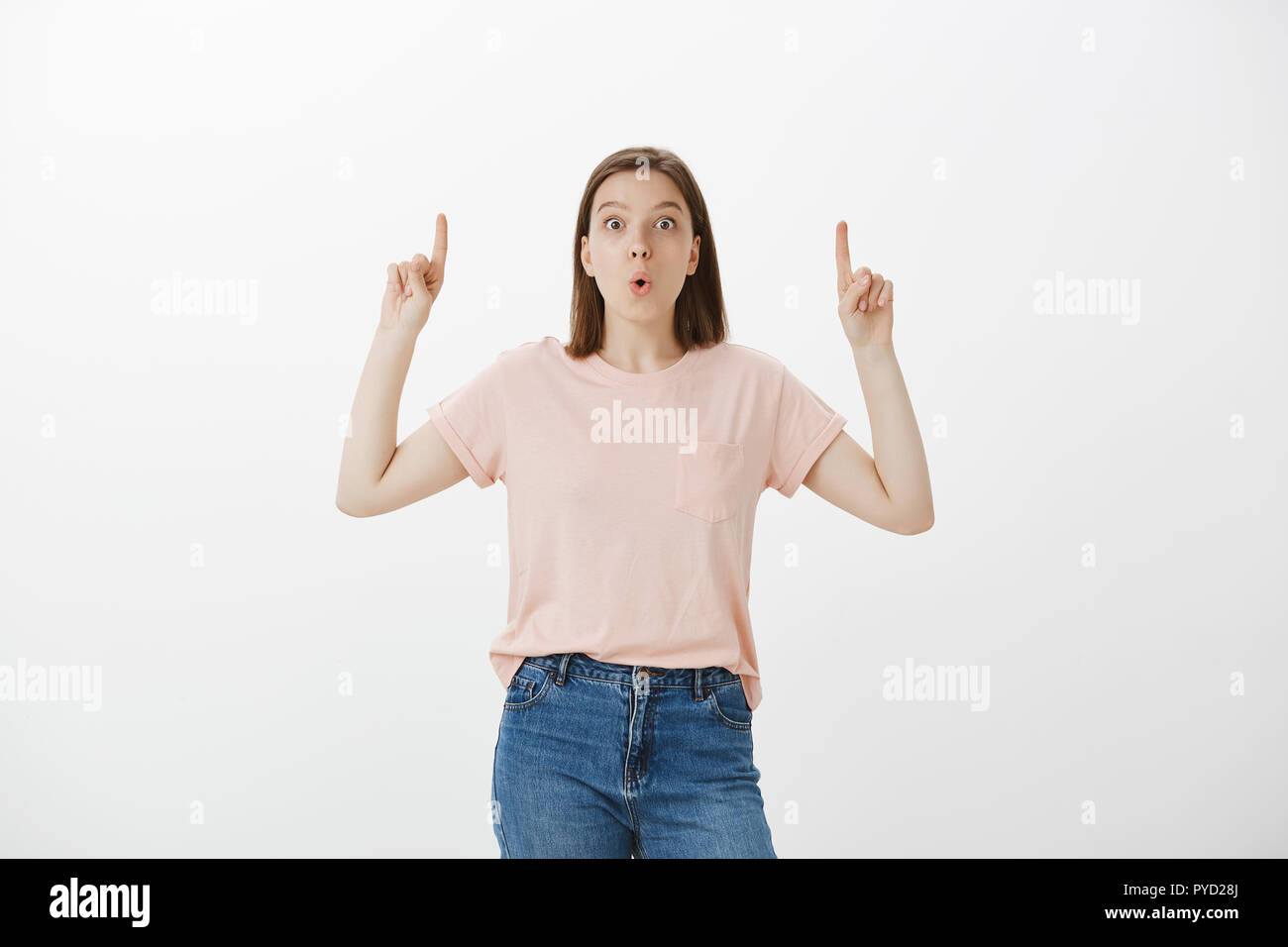 Overwhelmed impressed young girl in pink t-shirt and jeans, folding ...