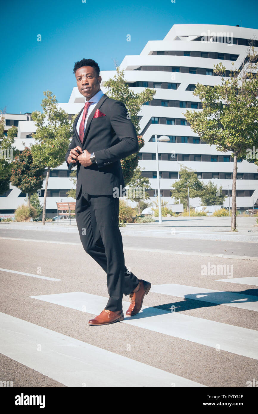 Close up of one young and attractive black businessman walking in the ...