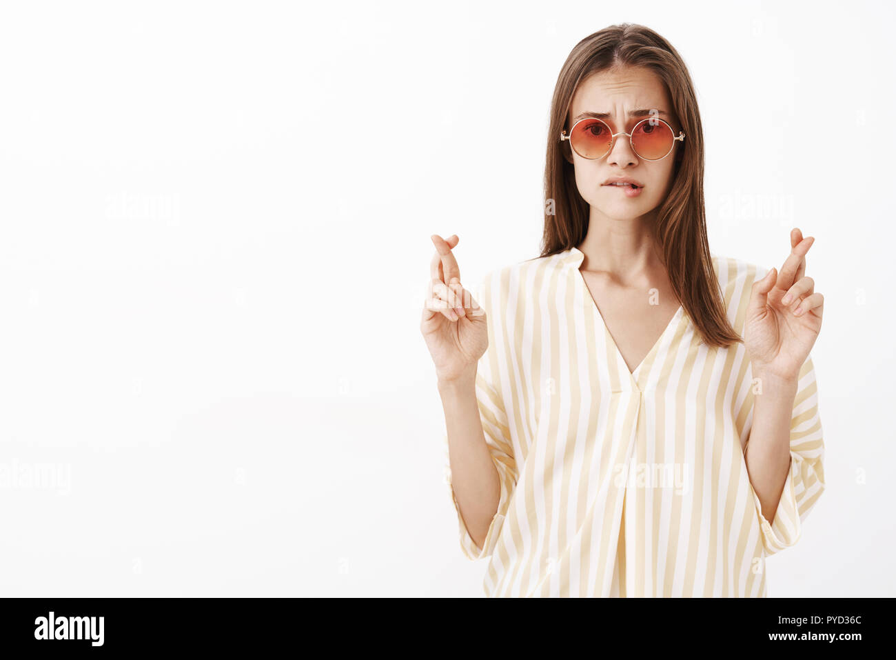 Worried sad good-looking stylish woman in trendy yellow striped blouse ...