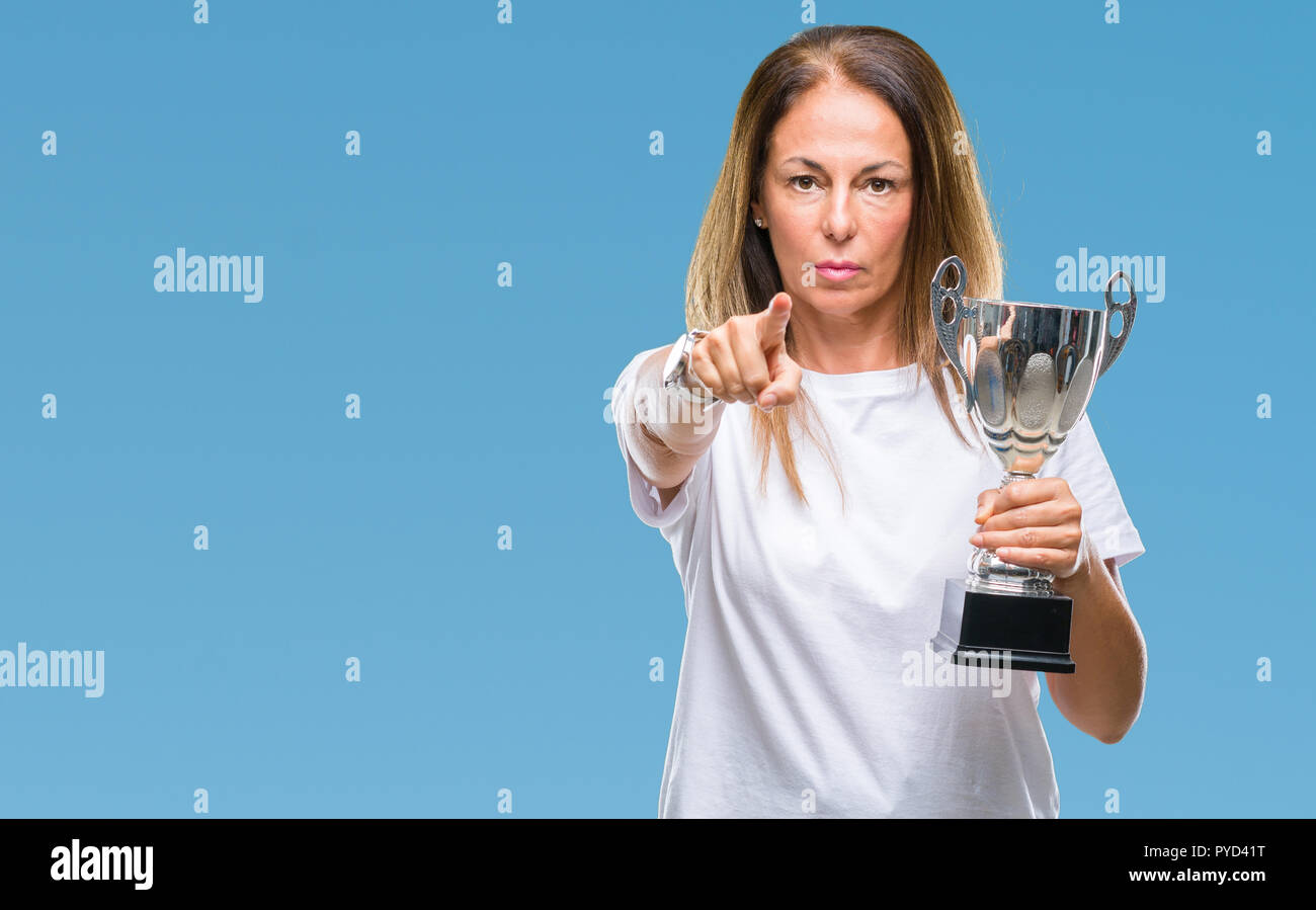 Middle age hispanic winner woman celebrating award holding trophy over ...