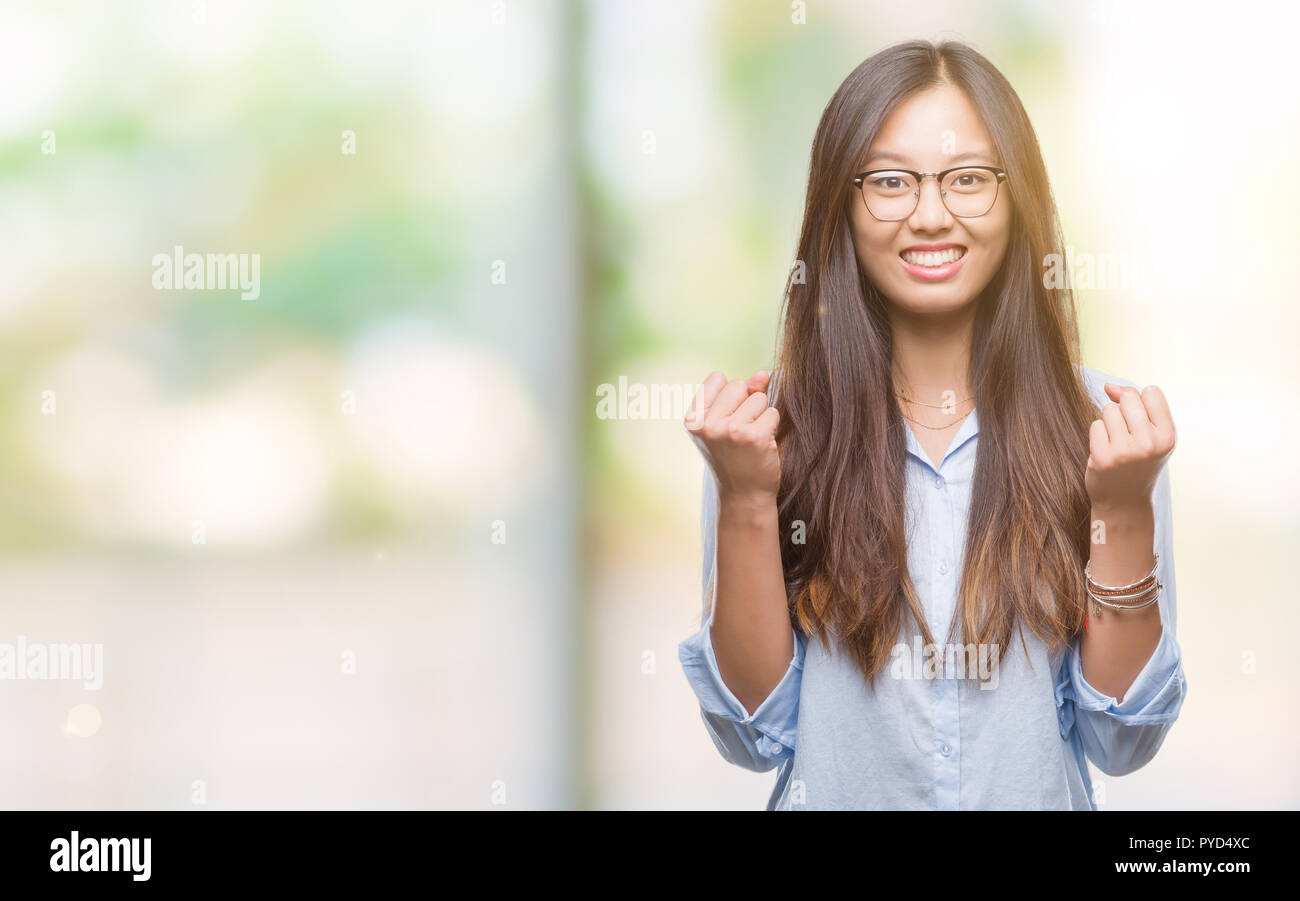 Young asian business woman wearing glasses over isolated background ...