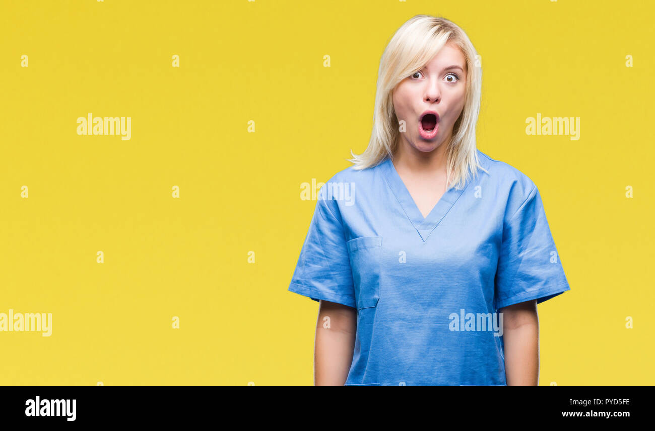 Young beautiful blonde nurse doctor woman over isolated background ...