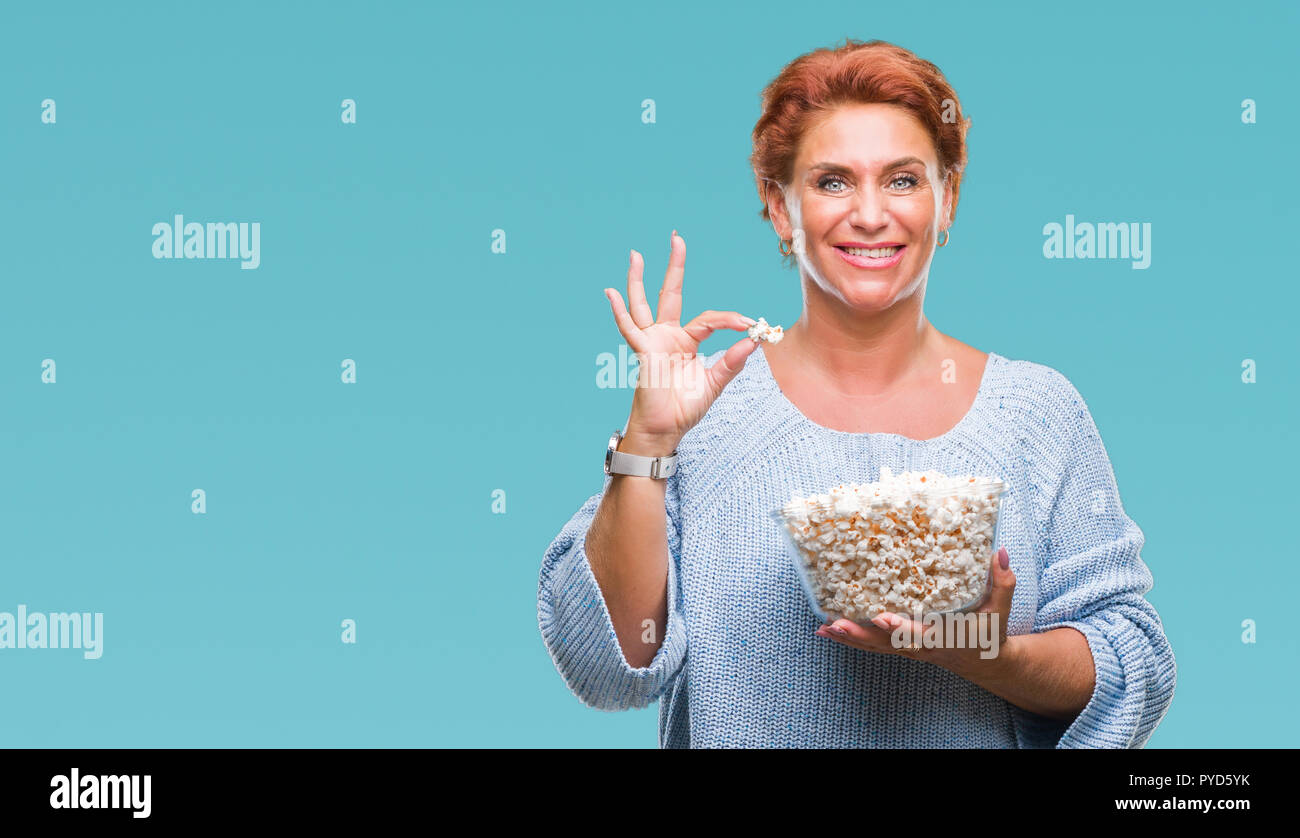 Atrractive Senior Caucasian Redhead Woman Eating Popcorn Over Isolated