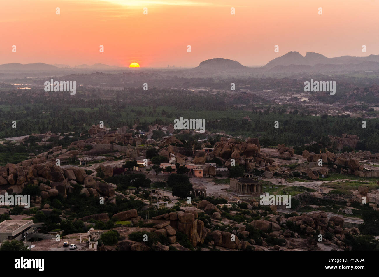 Scenic sunset over landscape dotted with giant boulders and ruins ...