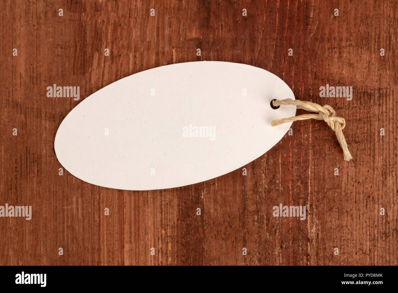 An overhead photo of an oval white paper label or price tag, shot from ...