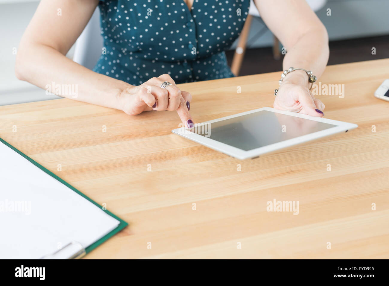 Female hands holding a tablet on office table Stock Photo - Alamy