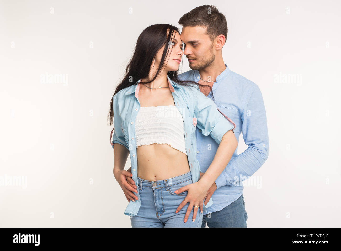 Love and people concept - beautiful young woman with boyfriend. He hugging her from behind on ...