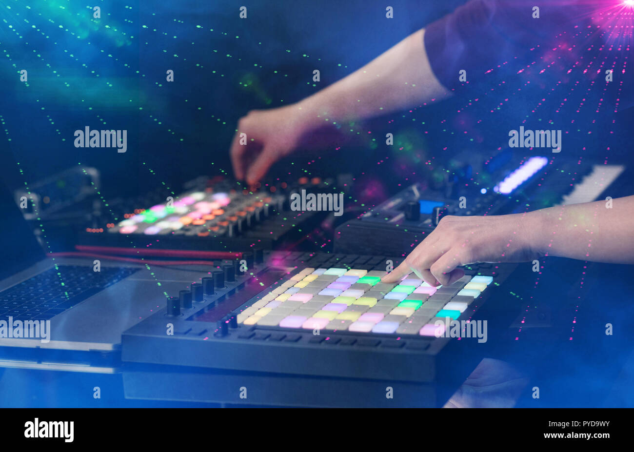 Hand mixing music on midi controller with party club colors around ...