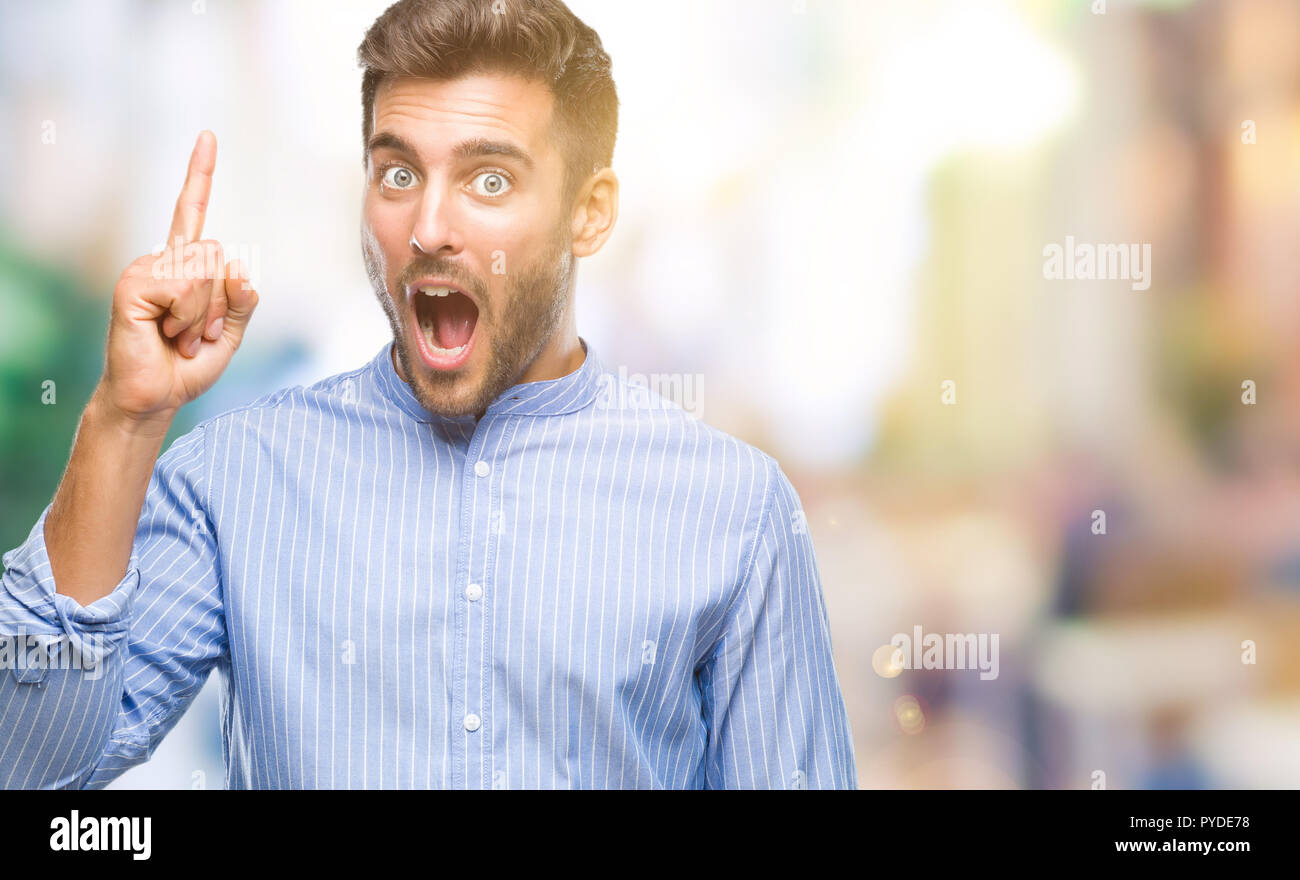 Young handsome man over isolated background pointing finger up with ...