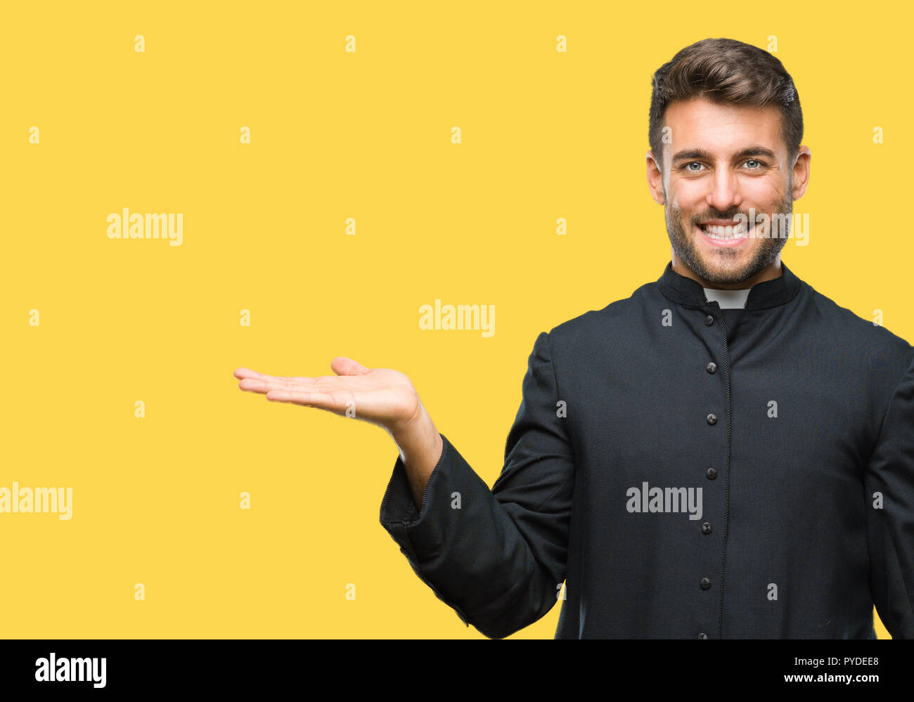Young catholic christian priest man over isolated background smiling ...