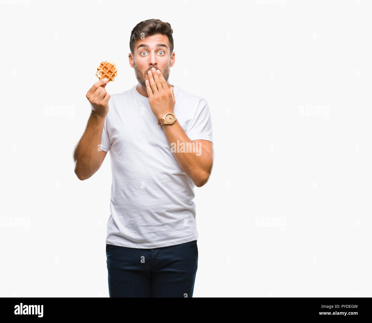 Young handsome man eating a sweet waffle over isolated background cover ...