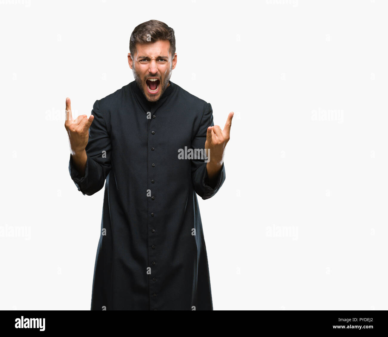 Young catholic christian priest man over isolated background shouting ...