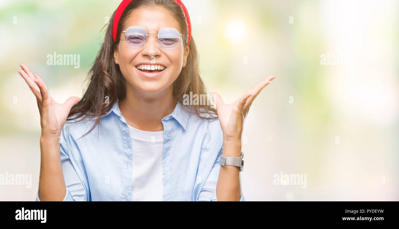 Young beautiful arab woman wearing sunglasses over isolated background ...