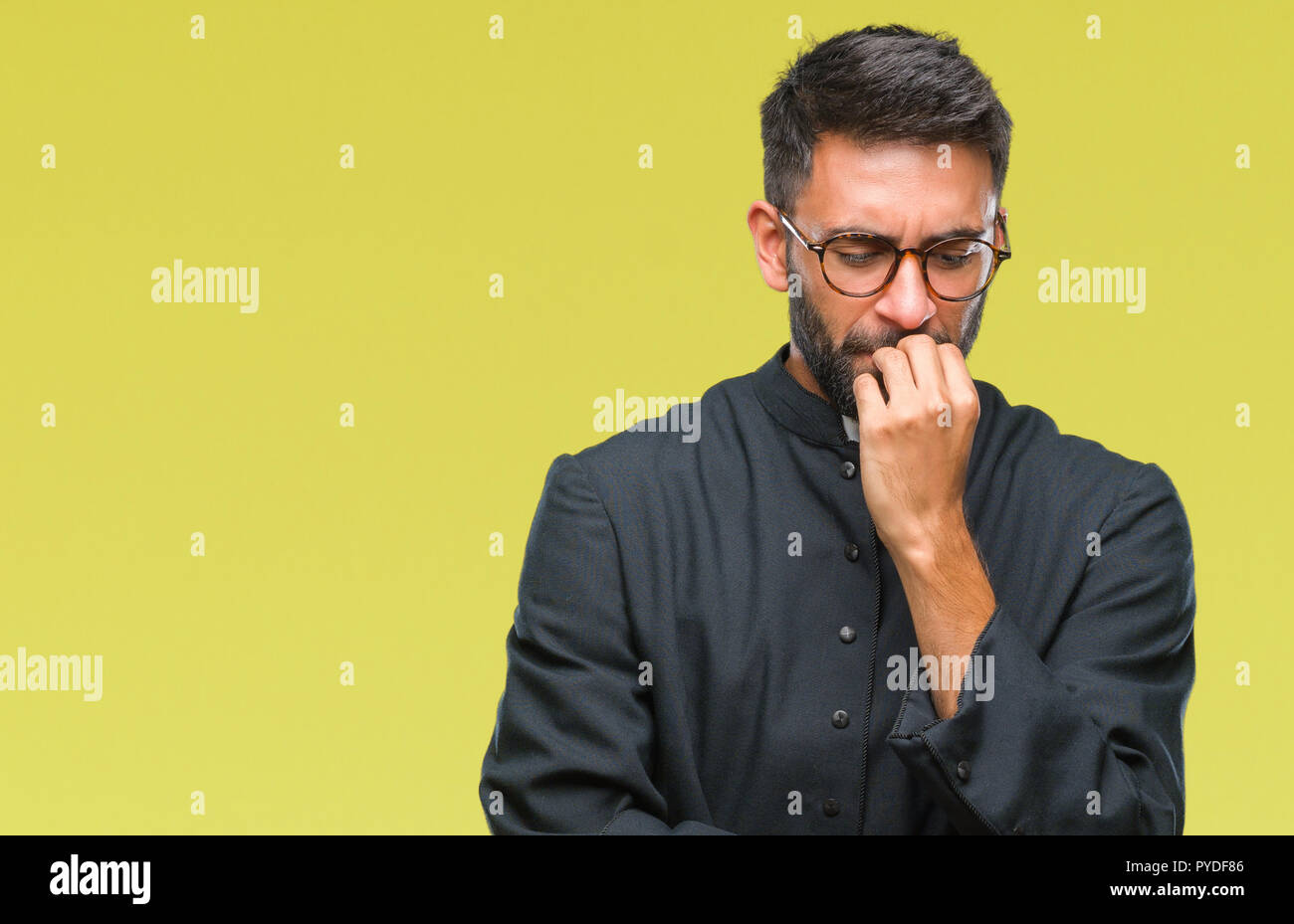 Adult hispanic catholic priest man over isolated background looking ...