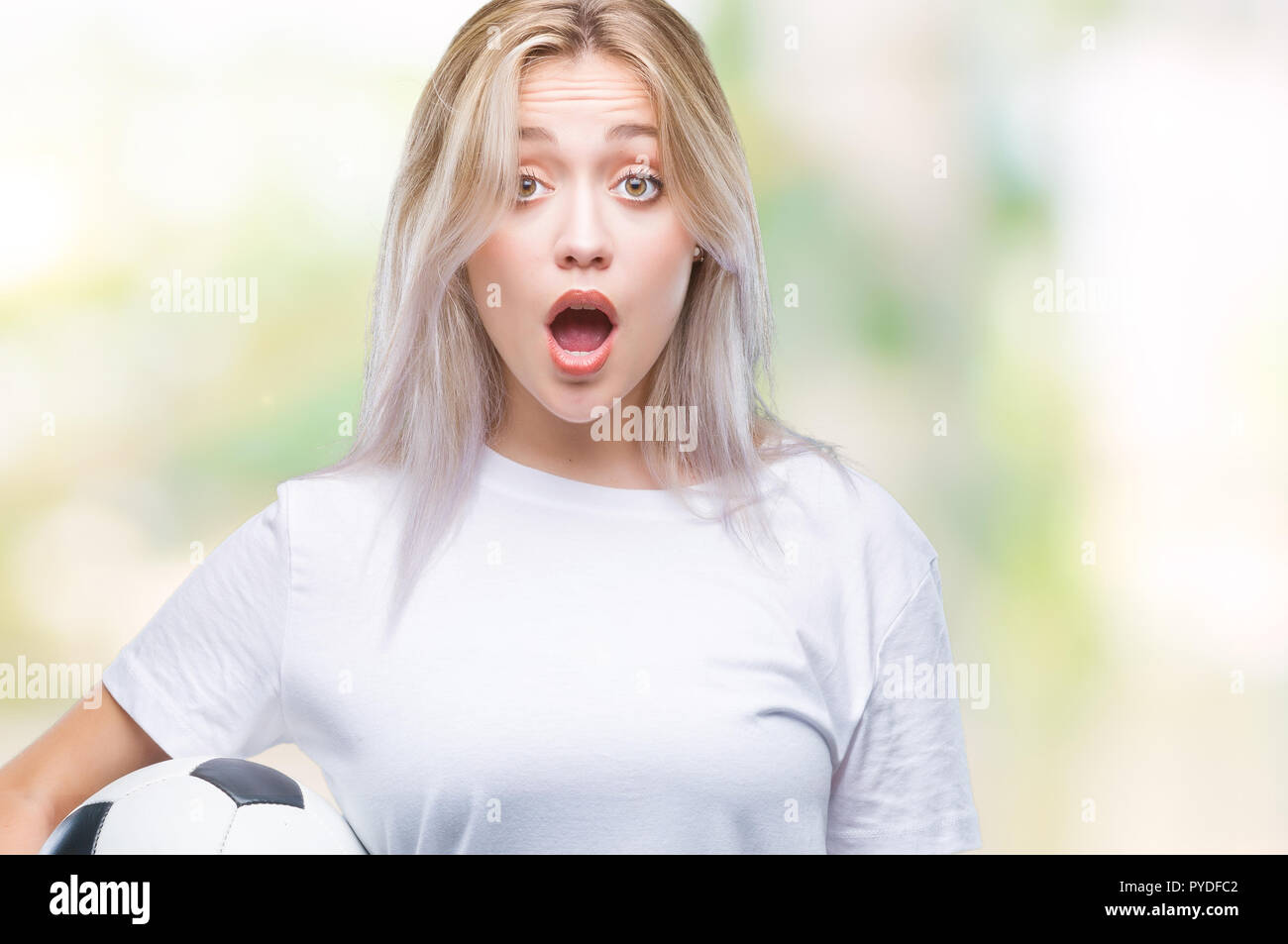 Young blonde woman holding soccer football ball over isolated ...