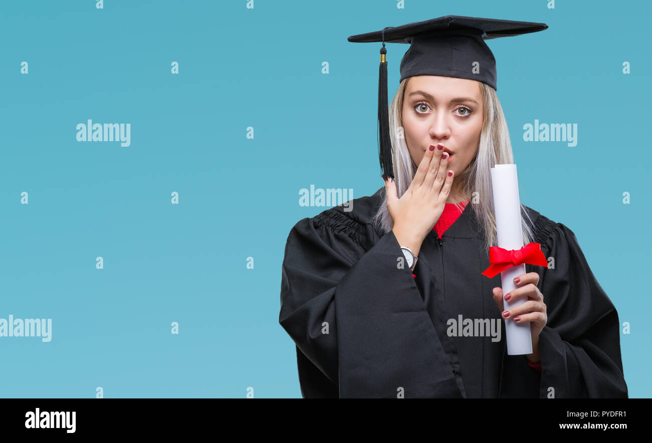 Young blonde woman wearing graduate uniform holding degree over ...
