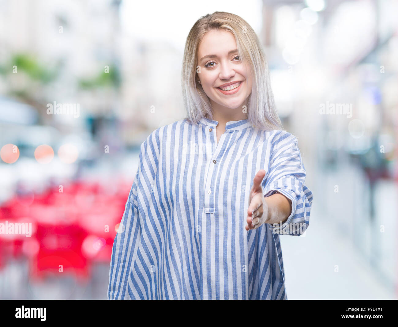 Young blonde woman over isolated background smiling friendly offering ...