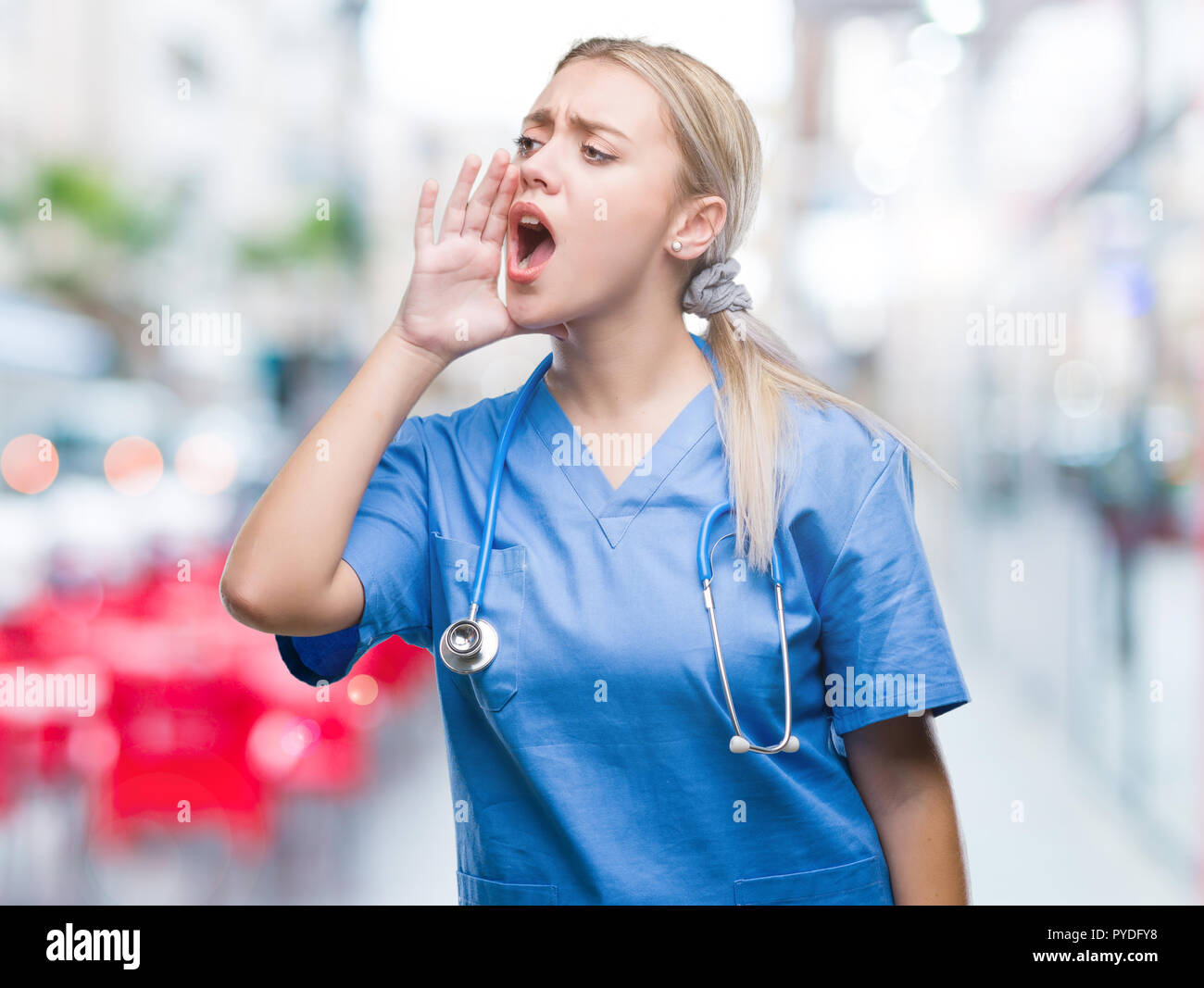 Young blonde surgeon doctor woman over isolated background shouting and ...