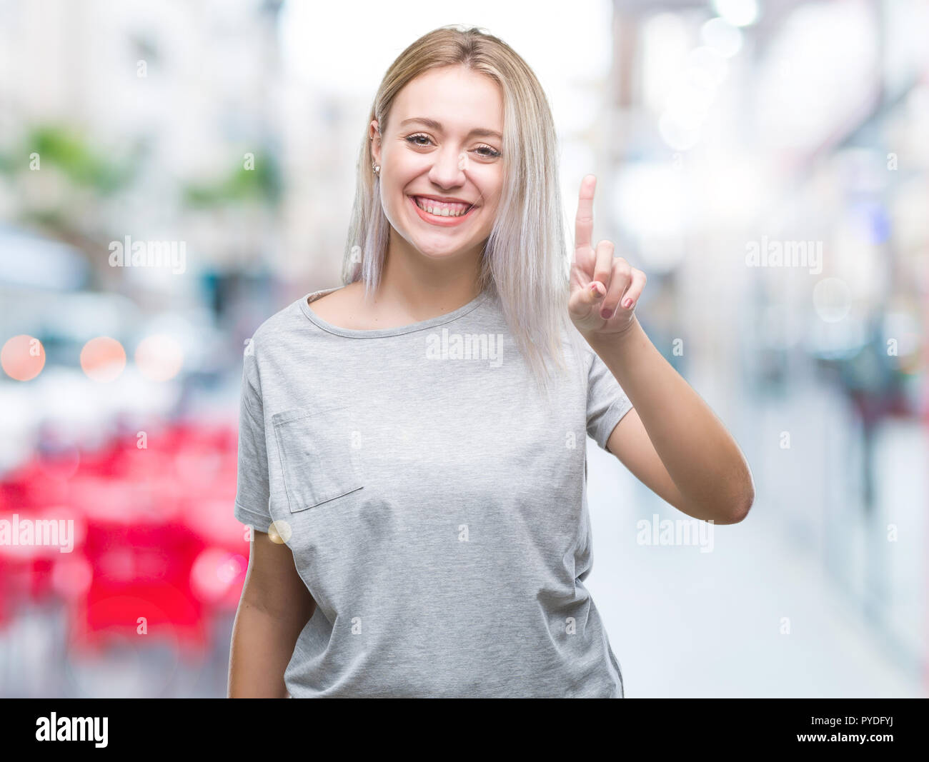 Young blonde woman over isolated background showing and pointing up ...