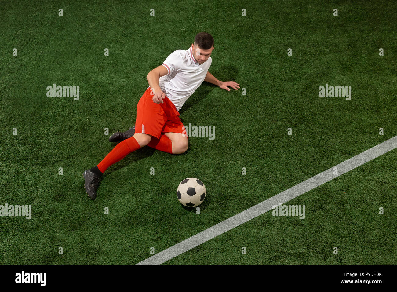 Football player tackling for ball over green grass background ...