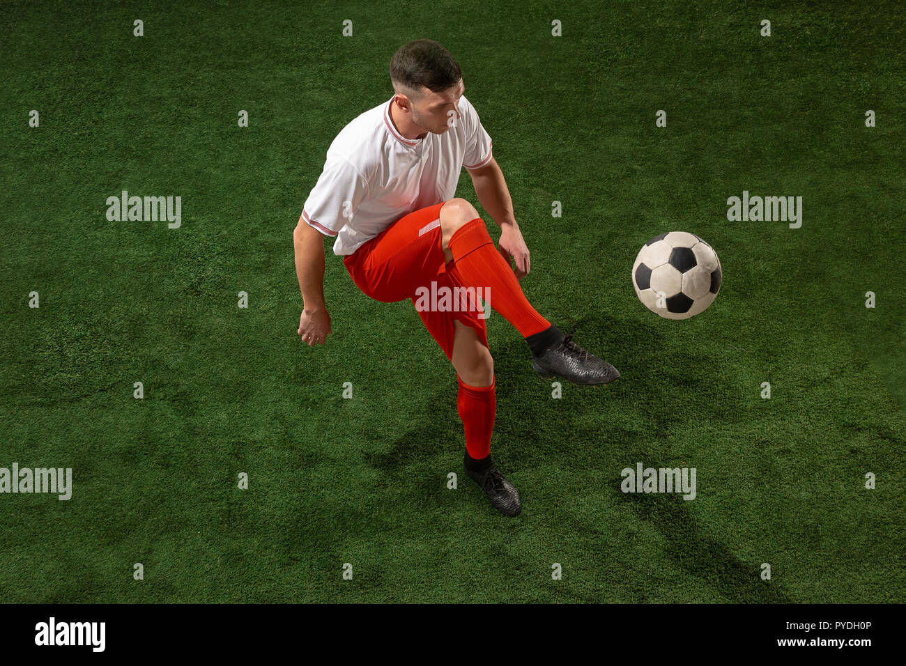 Football player tackling for ball over green grass background ...