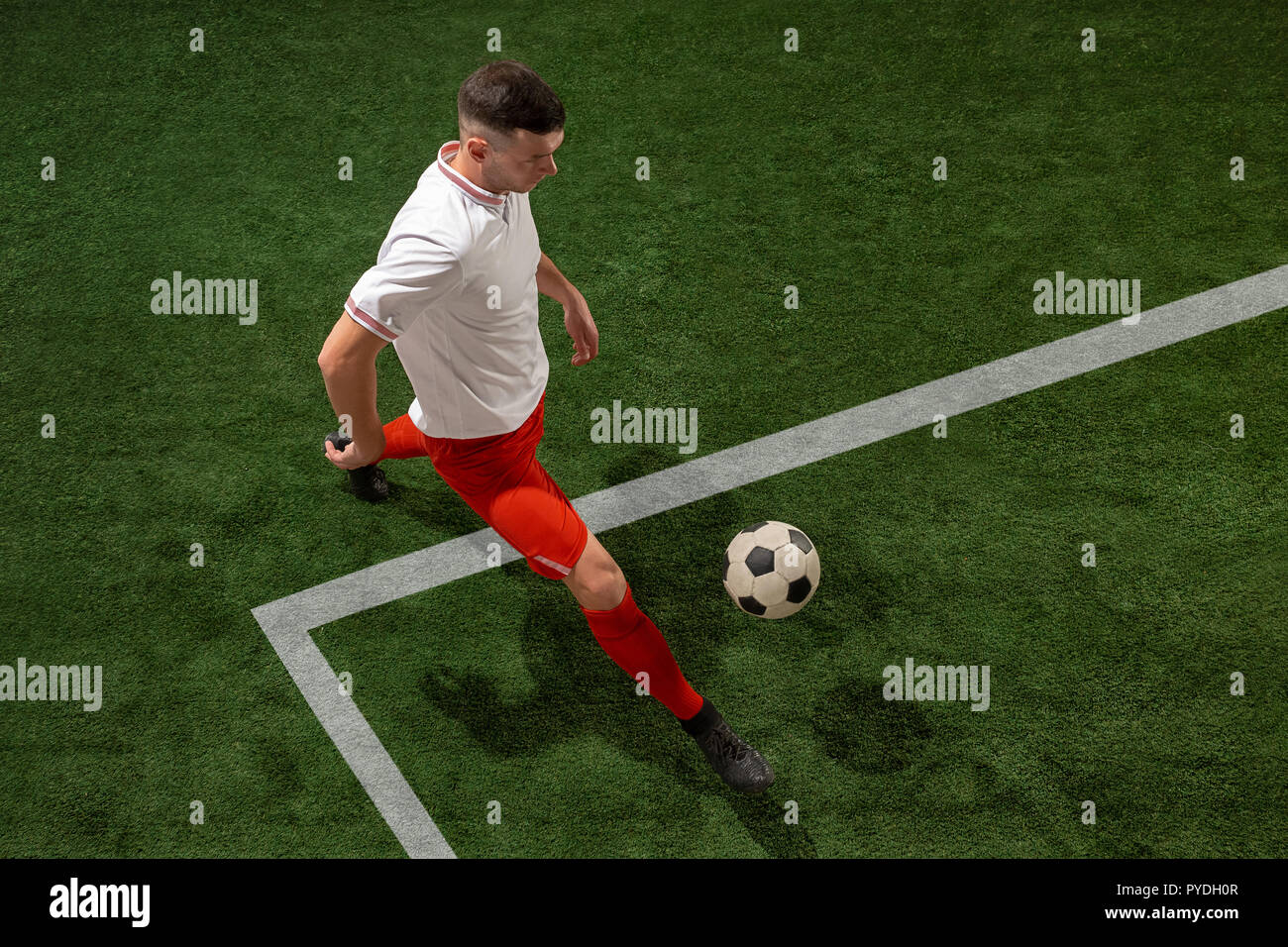 Football player tackling for ball over green grass background ...