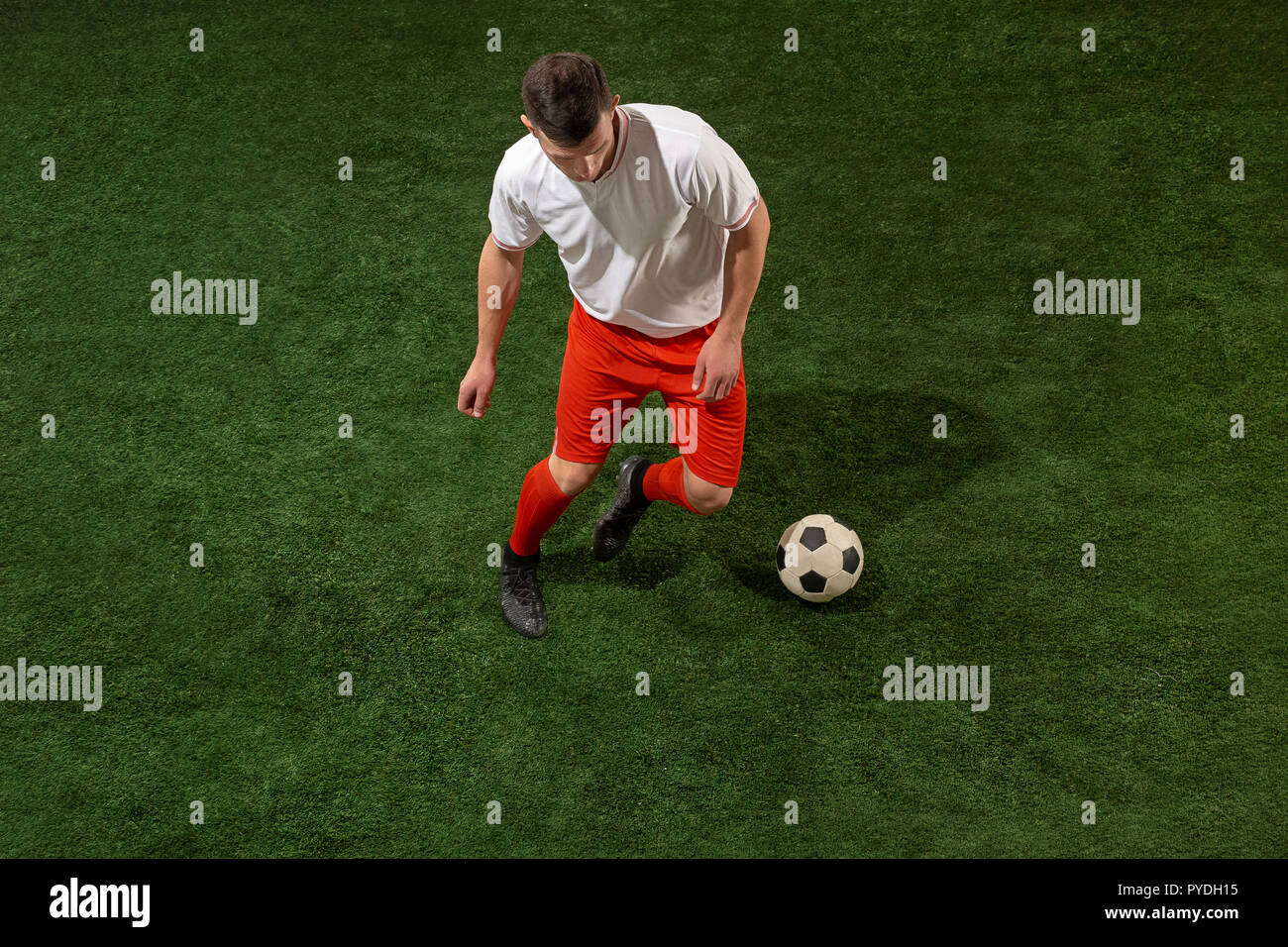 Football player tackling for ball over green grass background ...