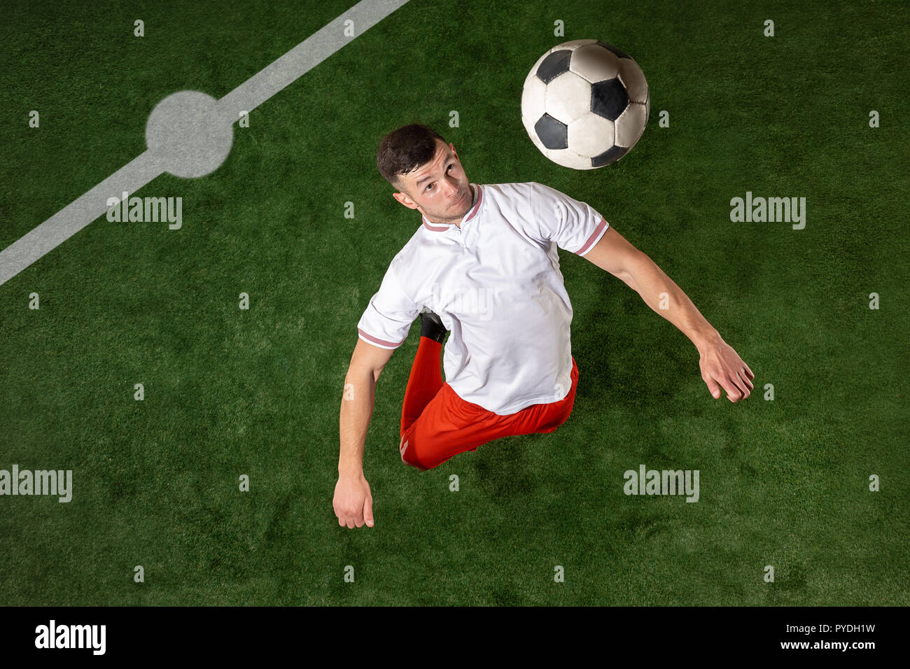 Football player tackling for ball over green grass background ...