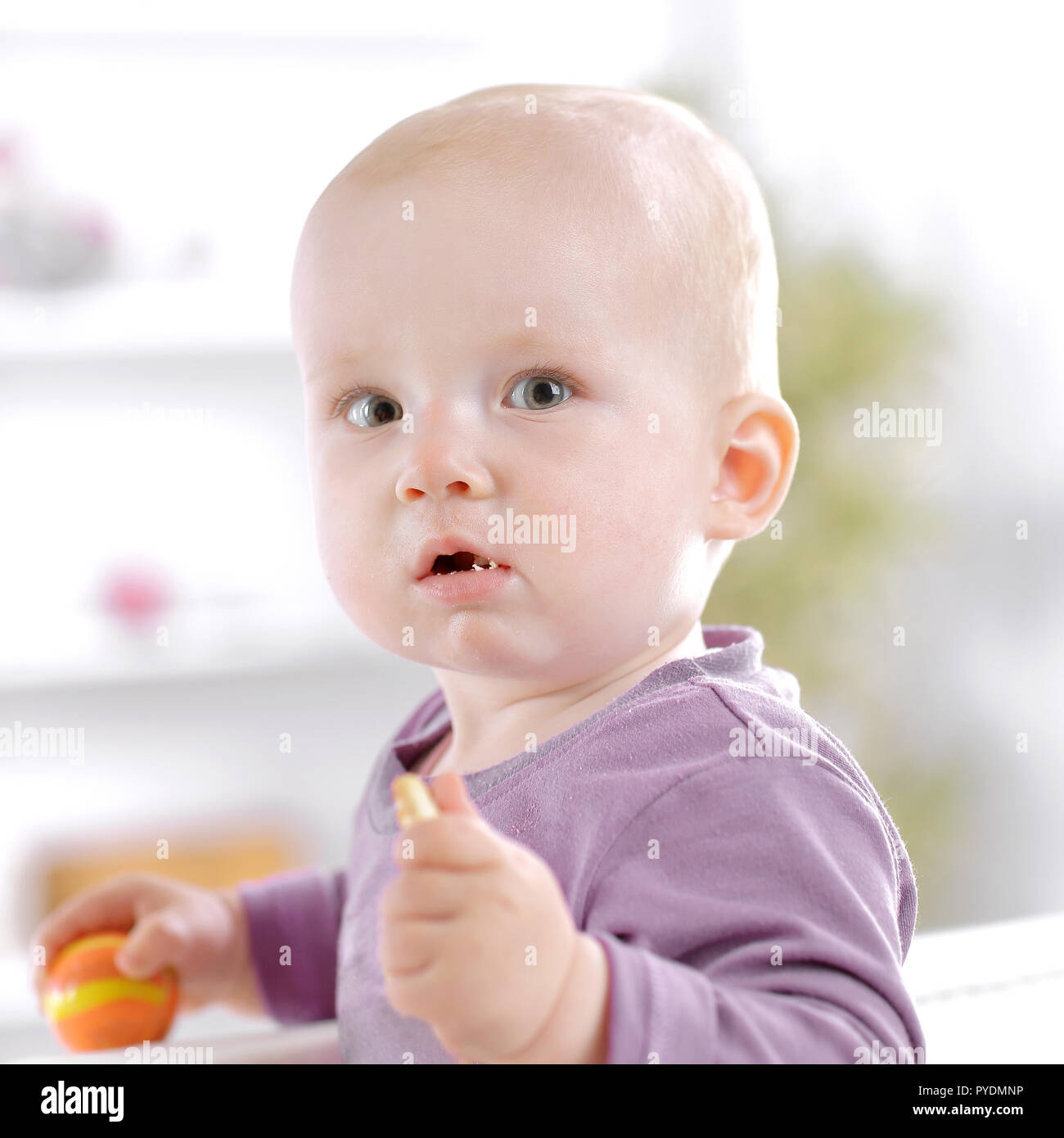 close up.cute baby eating a cookie while sitting on the couch Stock ...