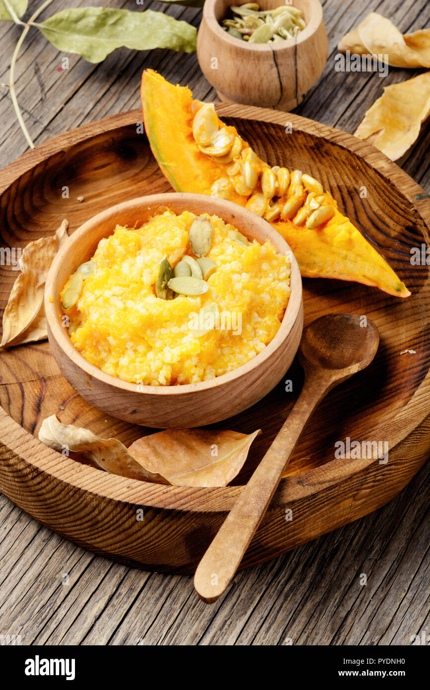 Homemade tasty porridge with orange pumpkin on rustic background ...