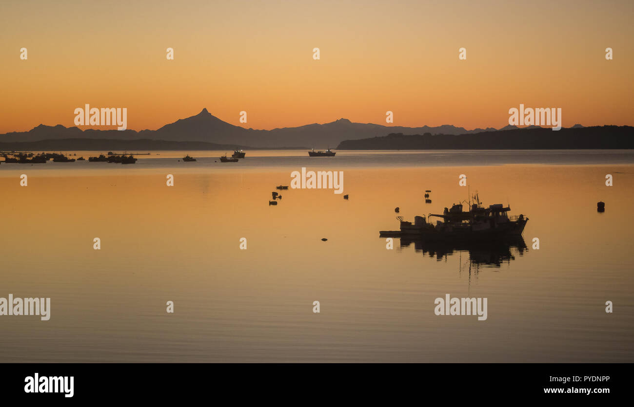 Sunrise at Quellón in Chiloé island with the Andes range and Corcovado ...
