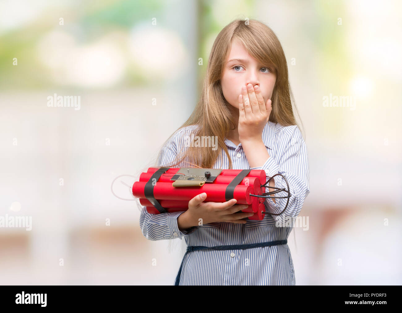 Young blonde child holding dynamite bomb cover mouth with hand shocked ...