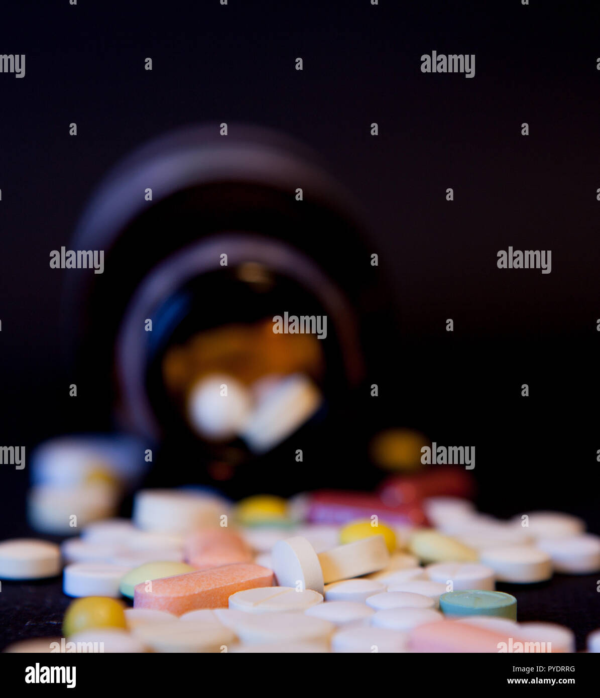A bottle of spilled pills on black background. Levitating tablets ...