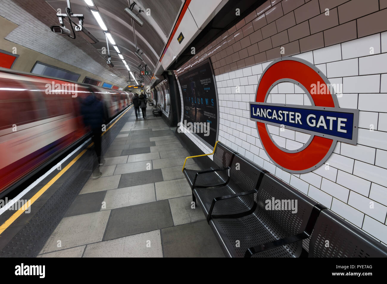 London Underground sign with moving train and people at Lancaster Gate ...