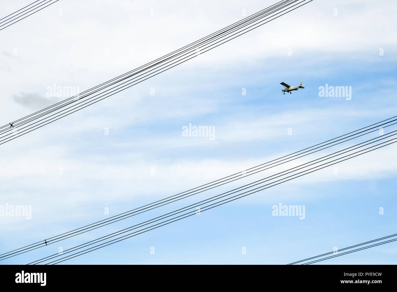 Light aircraft flying down the wires Stock Photo - Alamy