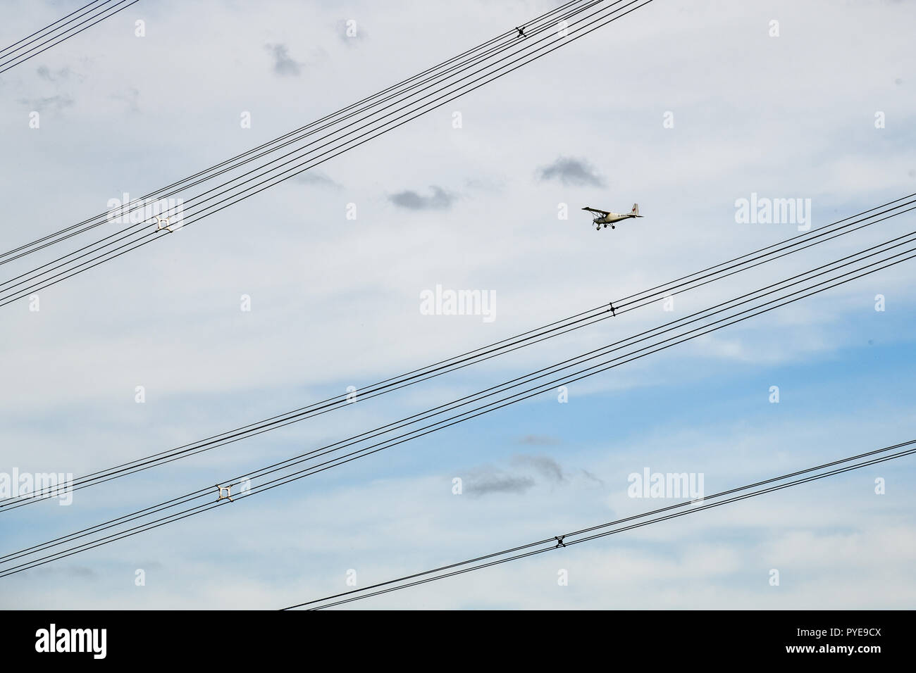 Light aircraft flying down the wires Stock Photo - Alamy