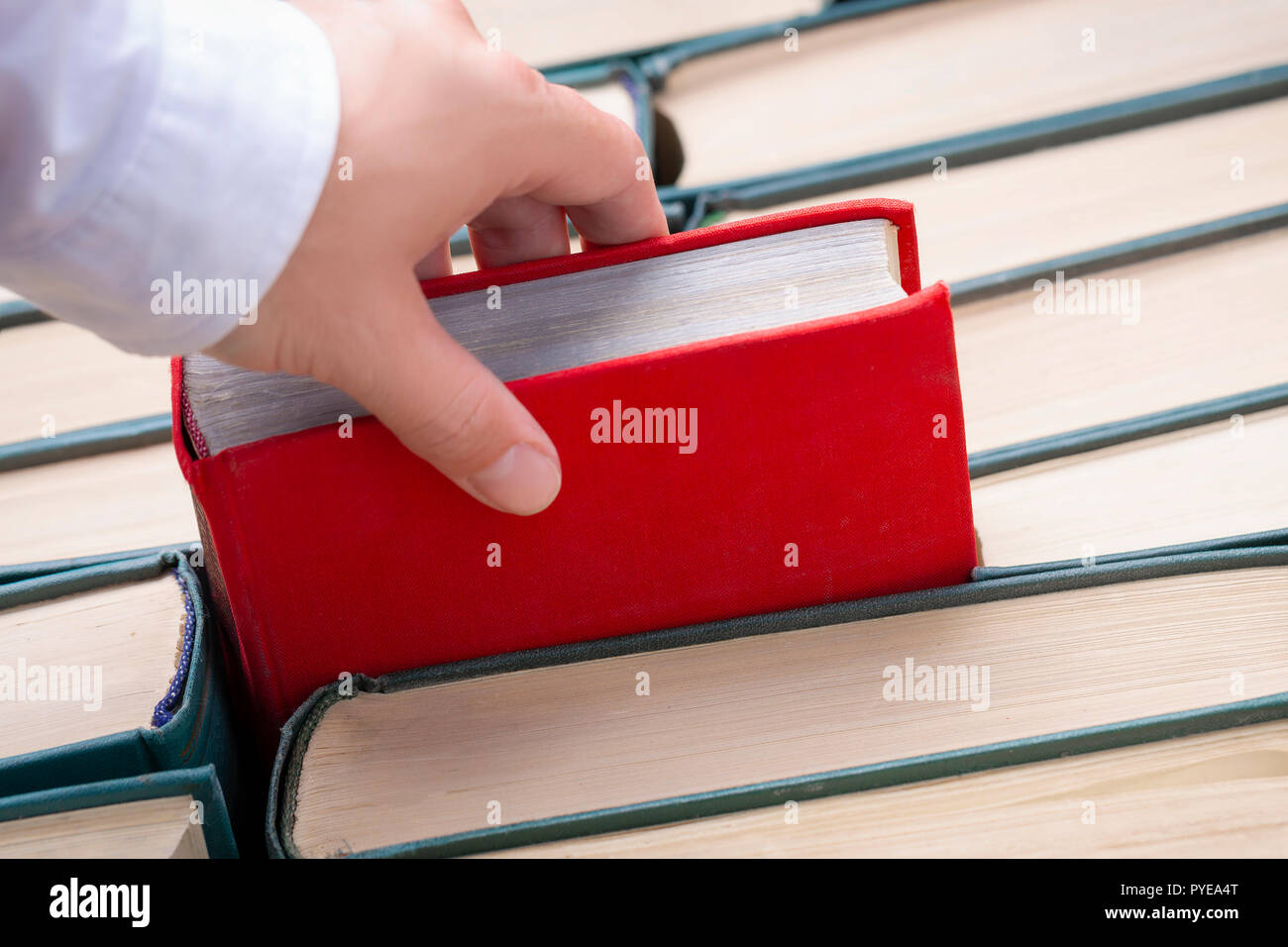 hand selecting a red book Stock Photo - Alamy
