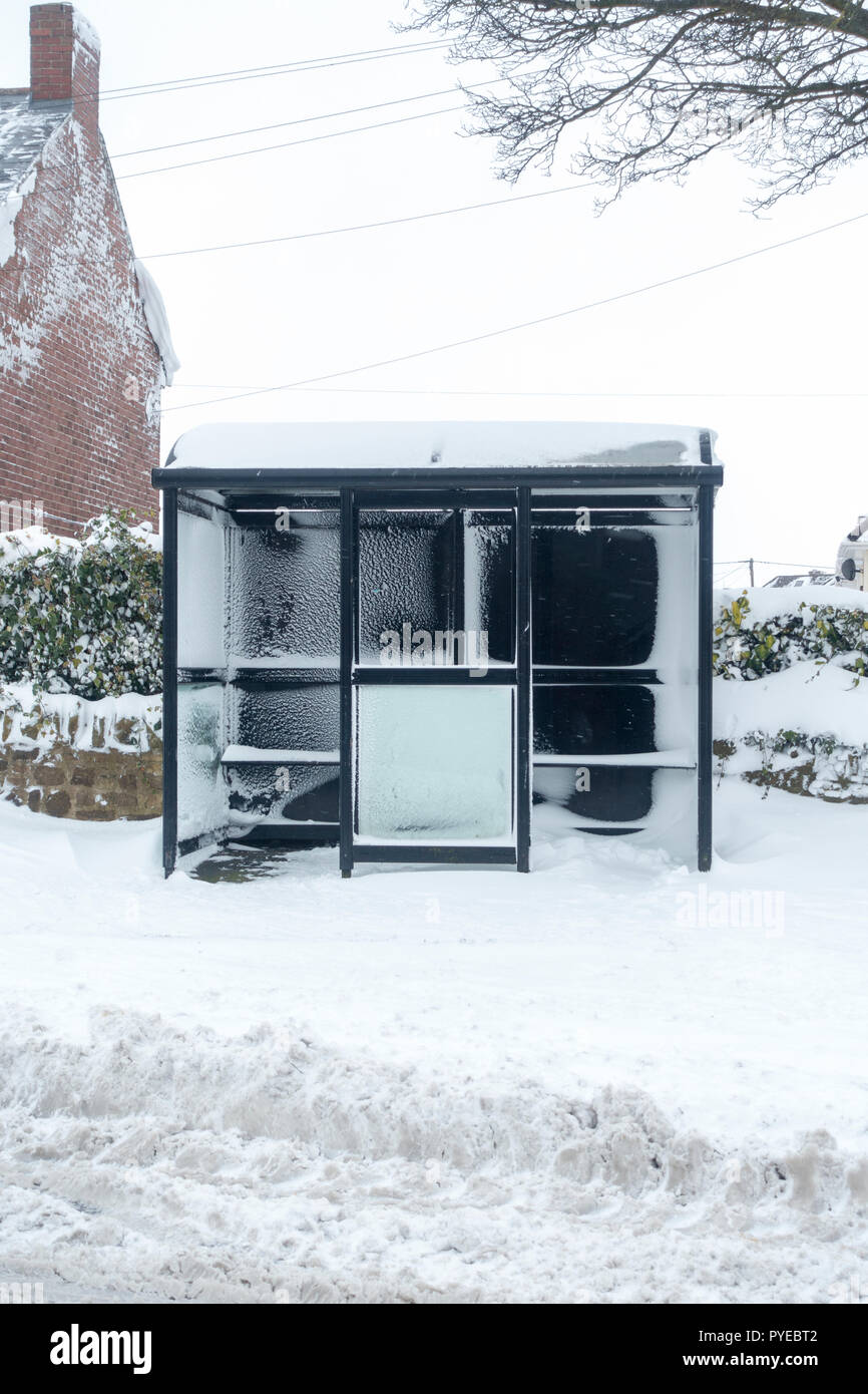 Modern steel and perspex bus stop or shelter at the side of a road ...