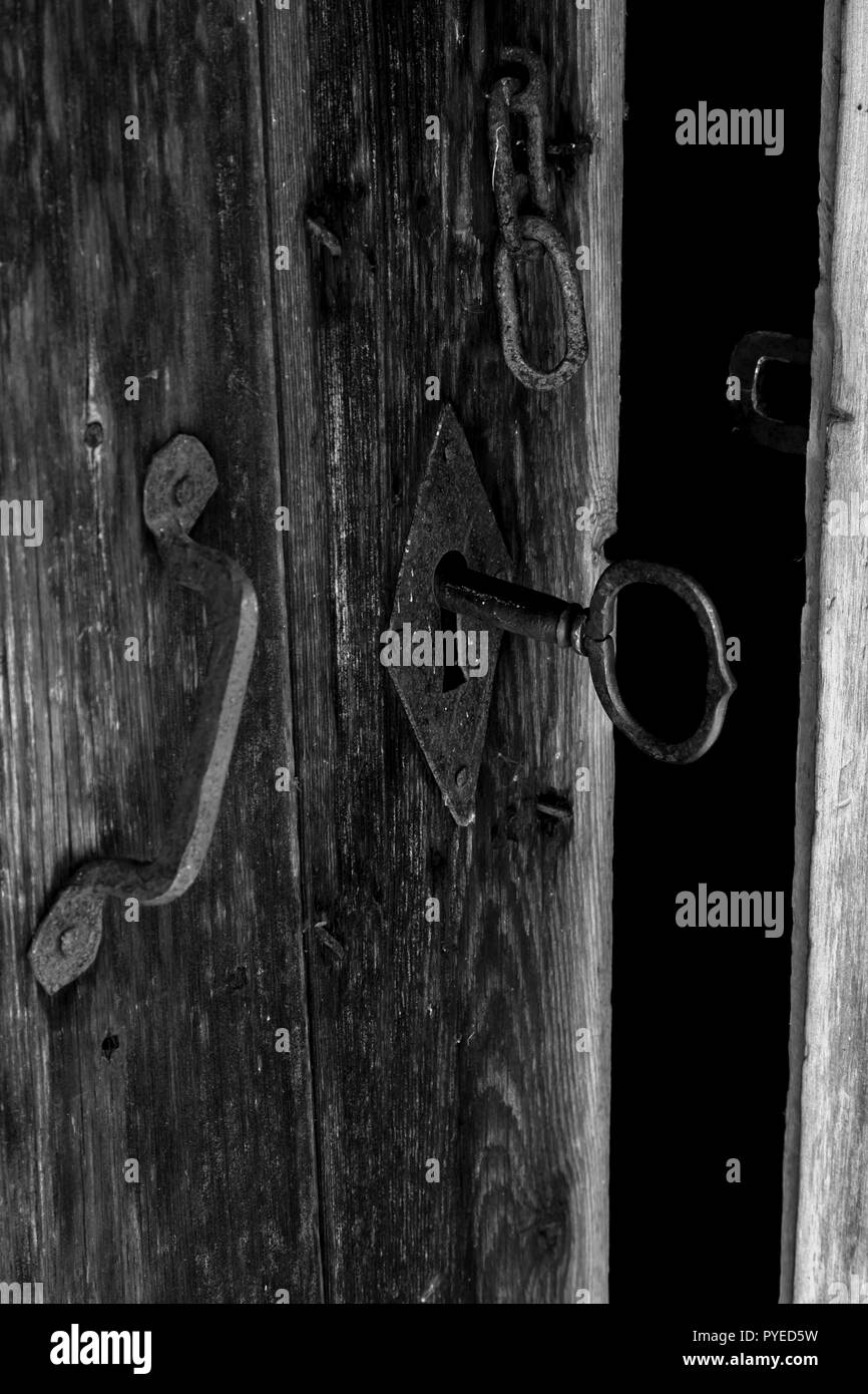 Rustic black iron skeleton key and door lock and handle in an old ...