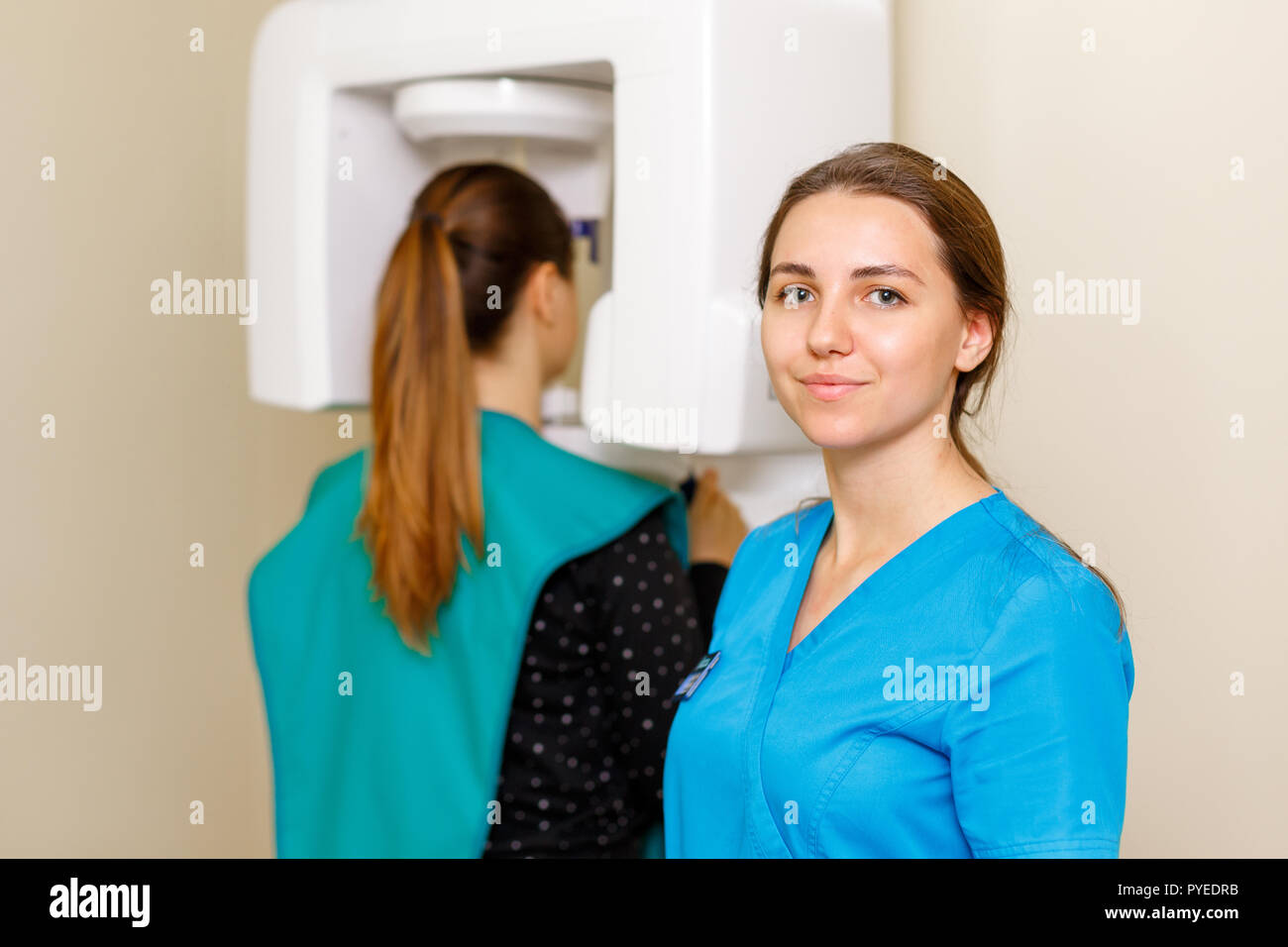 Young woman patient standing in x-ray machine. Panoramic radiography ...