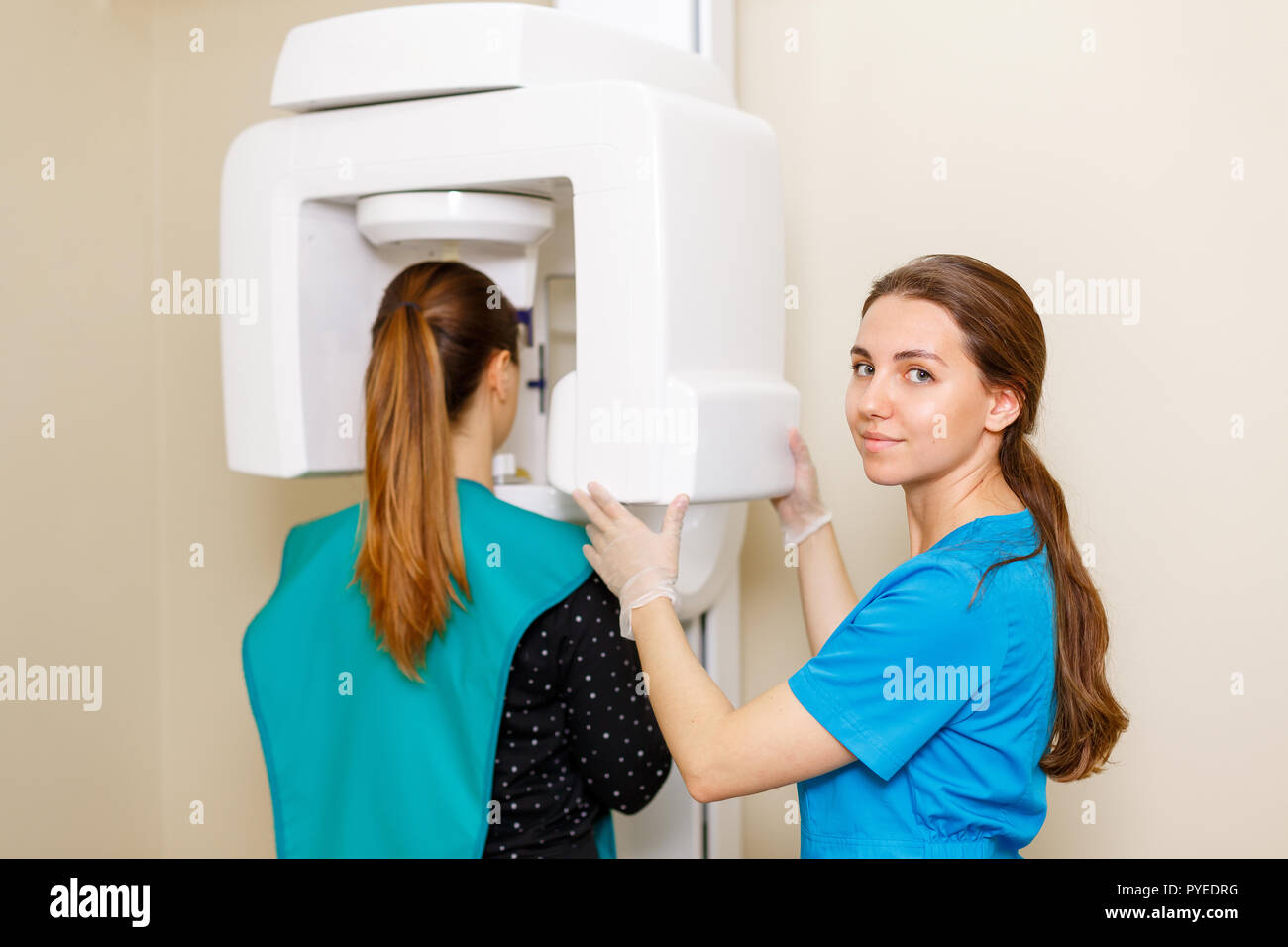 Young woman patient standing in x-ray machine. Panoramic radiography ...