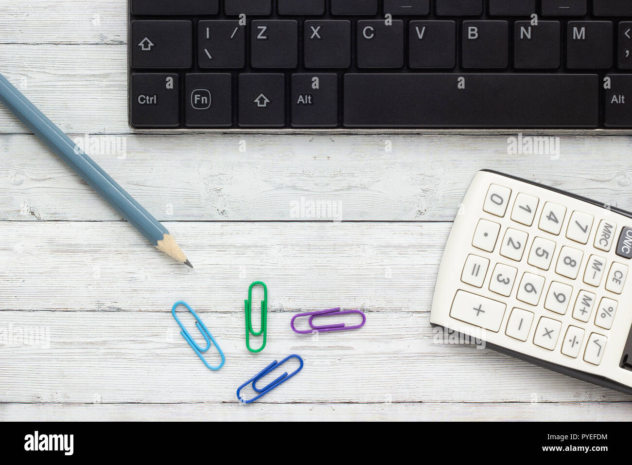 Keyboard, calculator and paper clips on wooden background Stock Photo ...