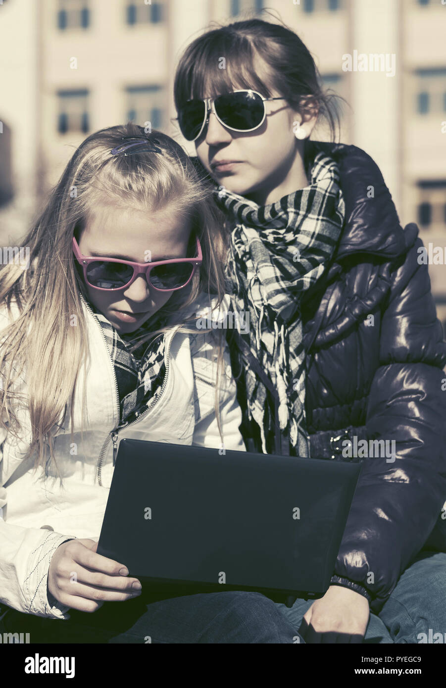 School girls using laptop on the bench Stock Photo - Alamy