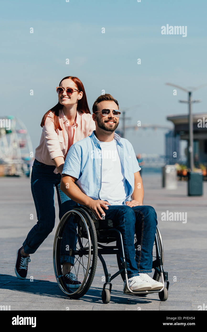 attractive girlfriend pushing handsome disabled boyfriend in wheelchair ...