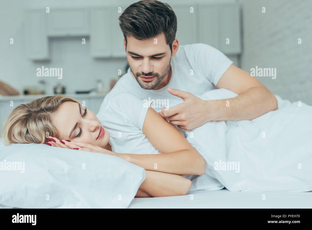 beautiful young couple cuddling in bed at home in morning Stock Photo ...