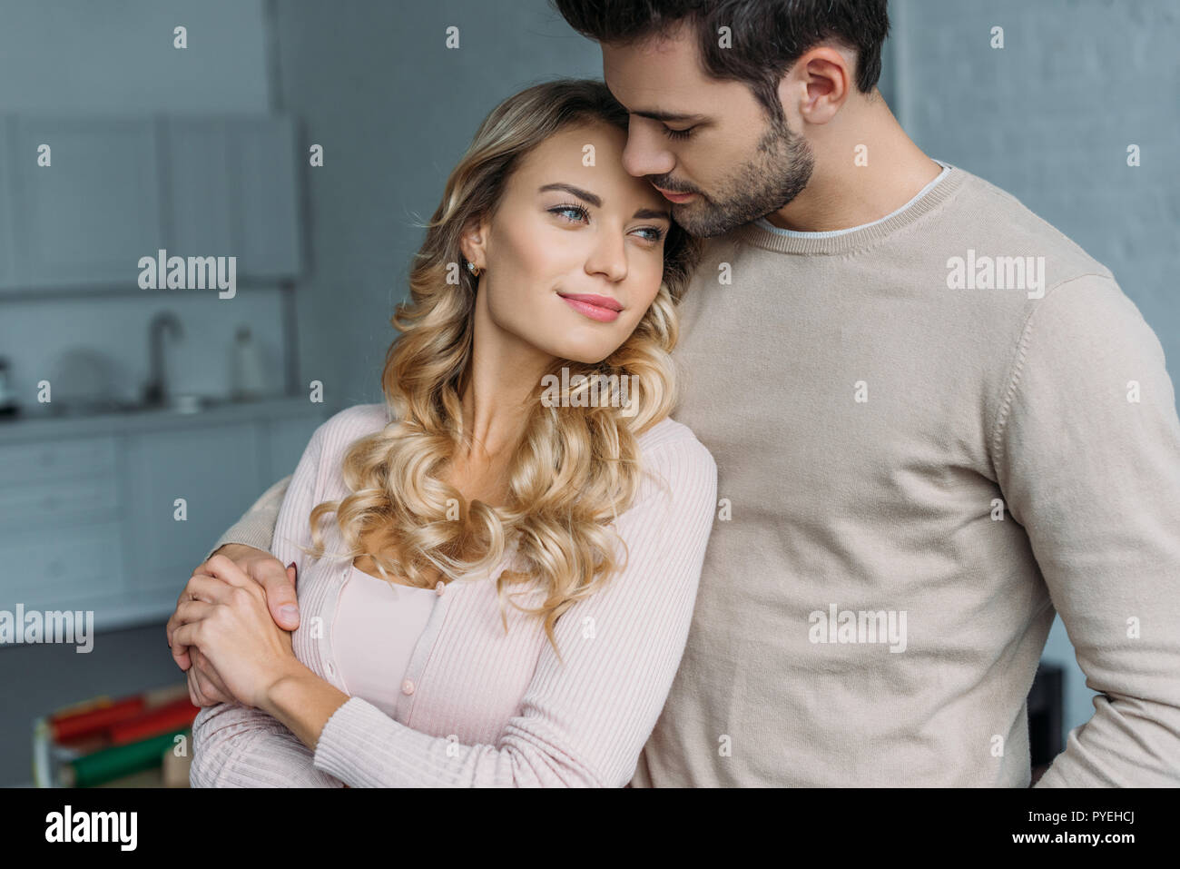 handsome boyfriend cuddling attractive girlfriend at home Stock Photo ...
