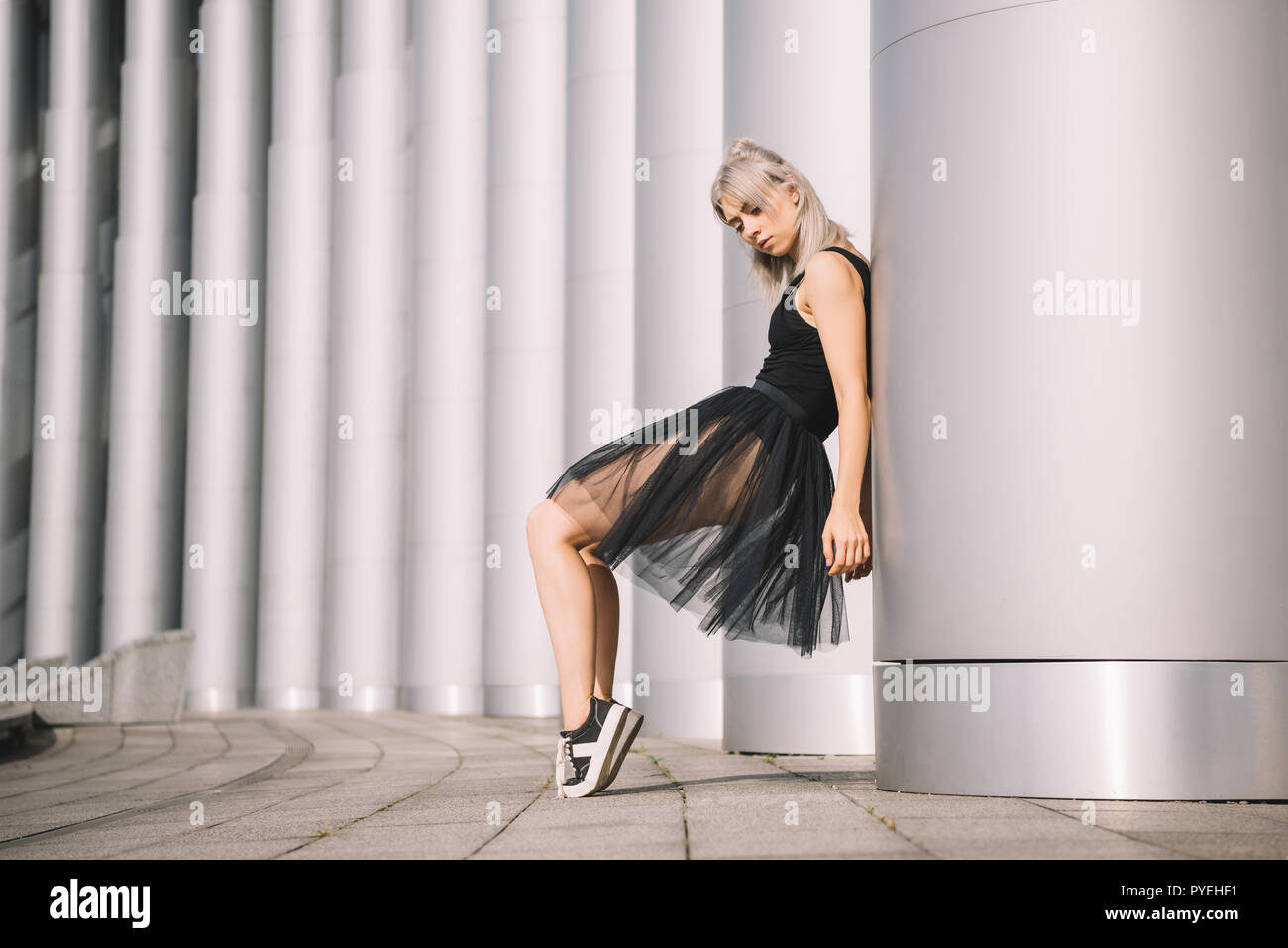 side view of beautiful young female dancer leaning at column Stock ...