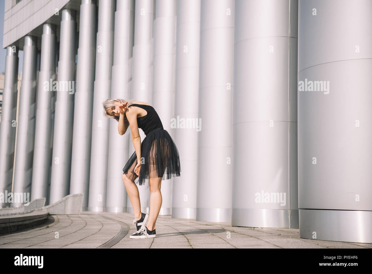 beautiful young female dancer standing near columns on street Stock ...