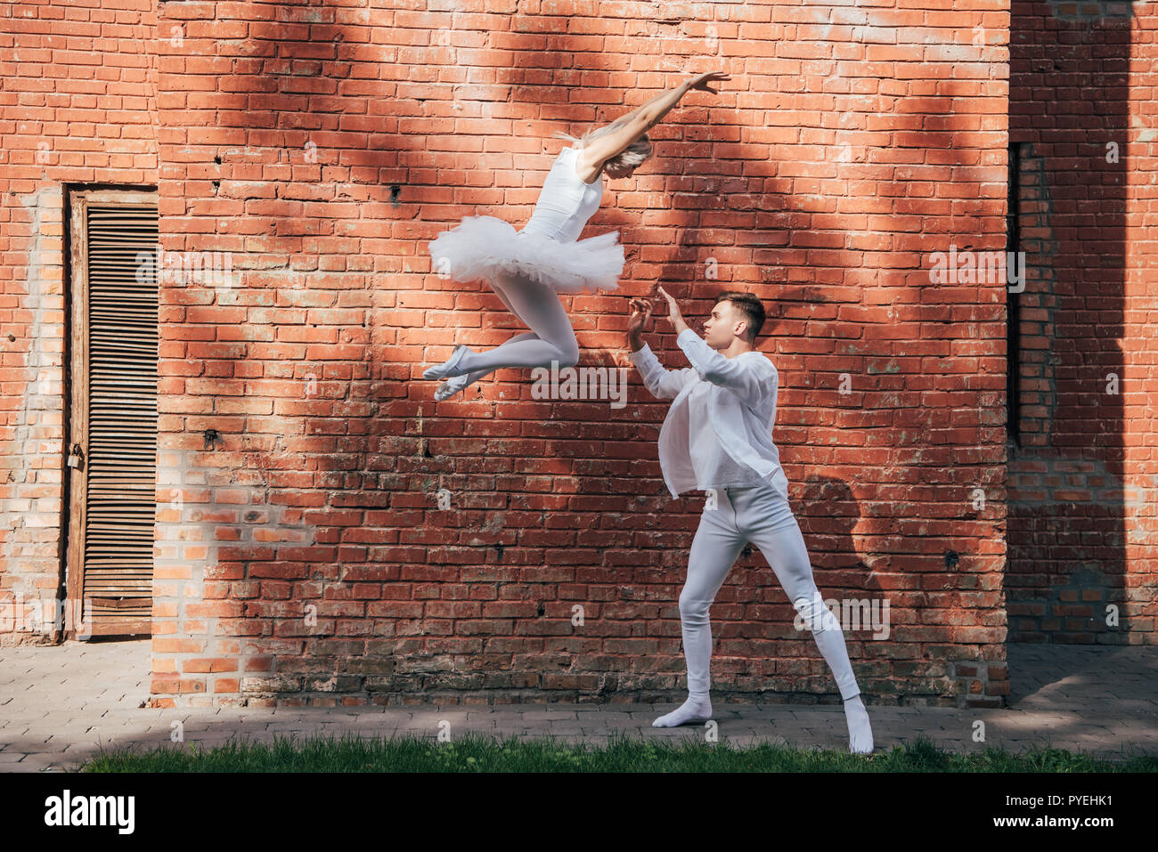 side view of beautiful young couple of dancers performing ballet dance ...